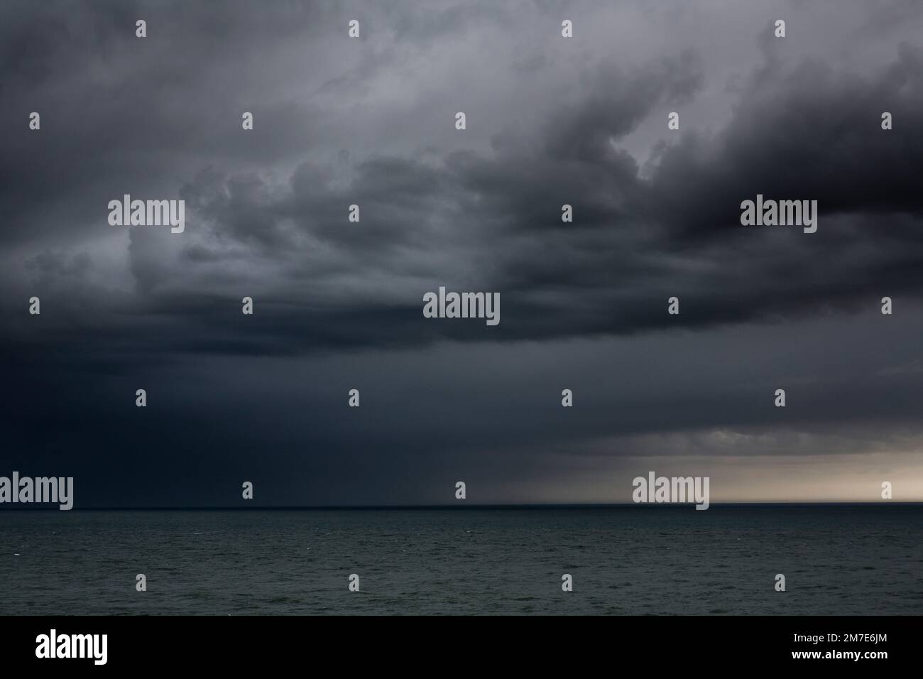 Dramatic dark grey storm clouds on the horizon over a dark forboding ...