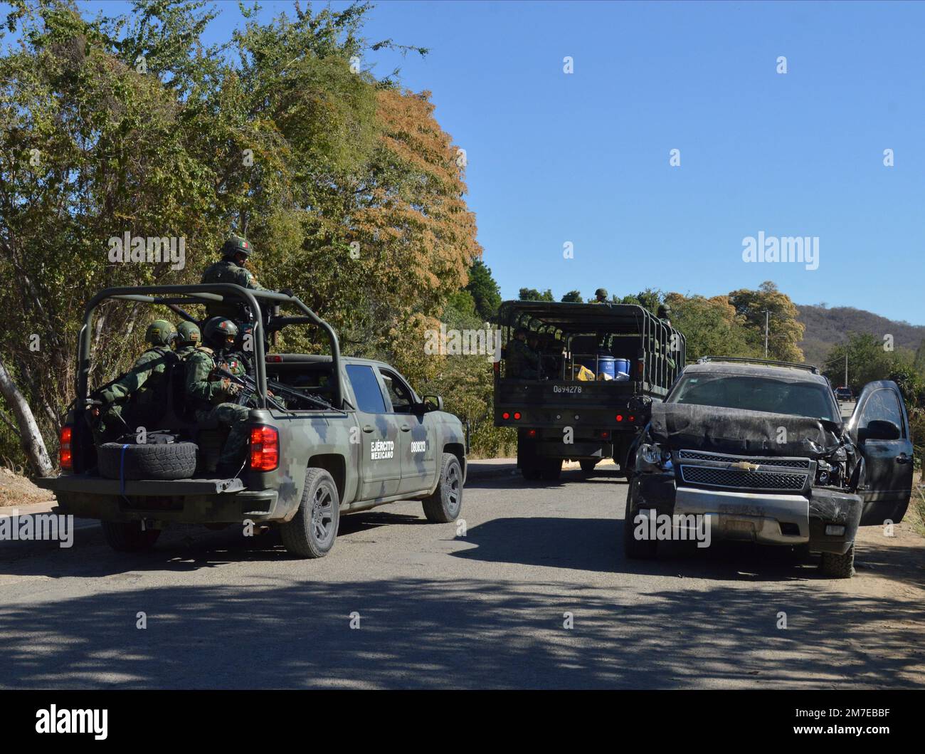 Army soldiers drive past a destroyed vehicle on the streets of Jesus ...
