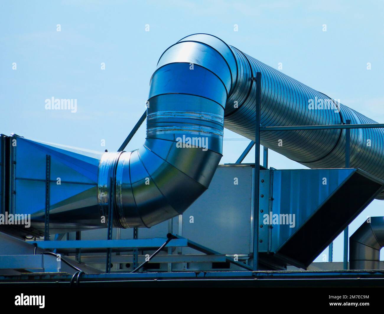 large shiny circular galvanized sheet steel mechanical air duct on flat ...