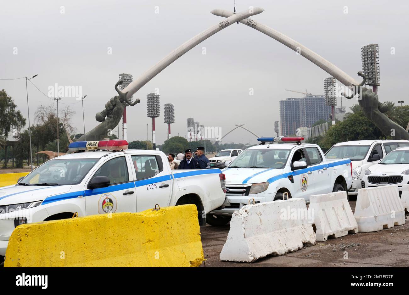 Iraqi traffic police officers stand at a busy intersection inside the ...