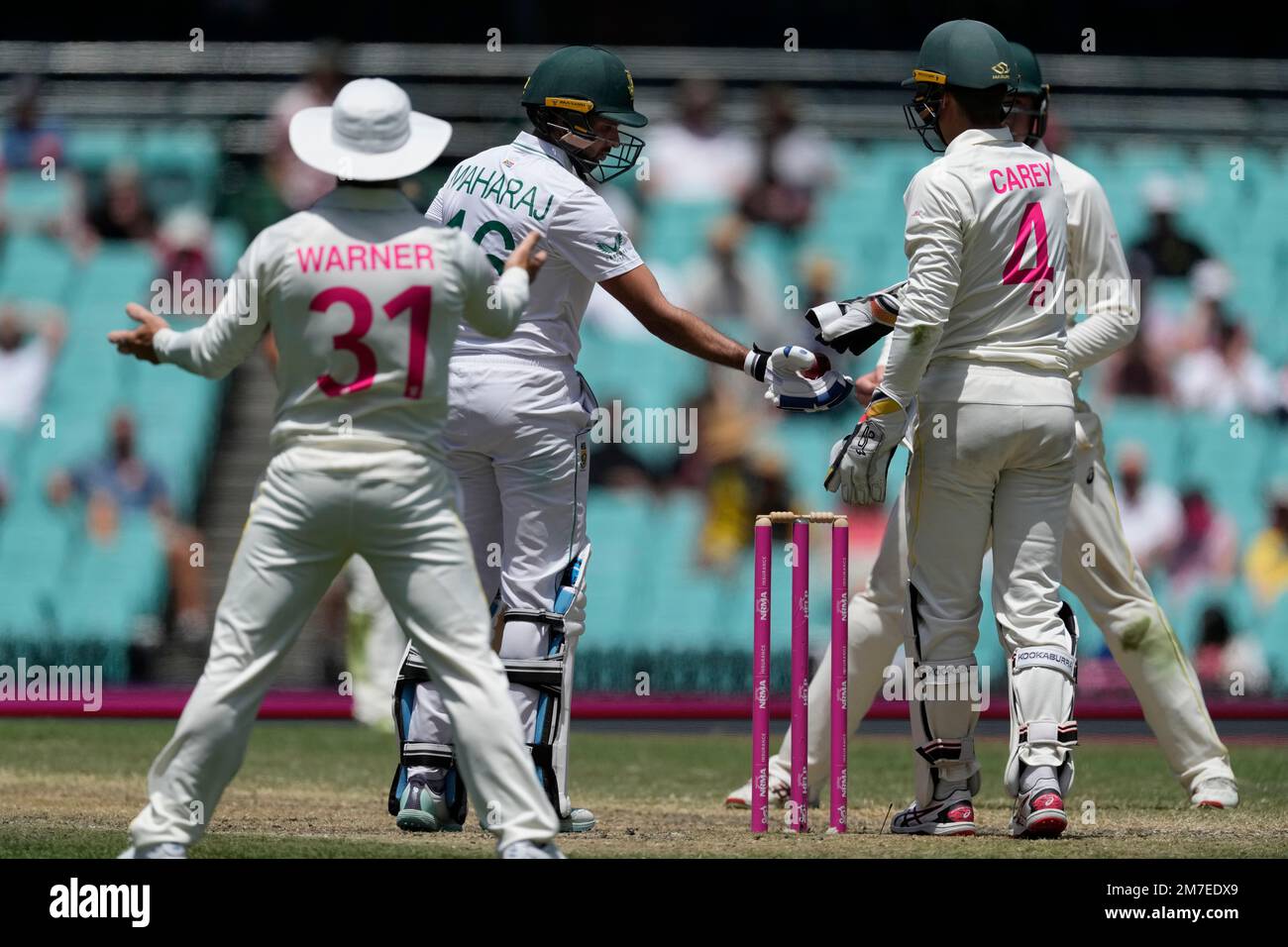 South Africa's Keshav Maharaj, second left, hands the ball to Australia ...