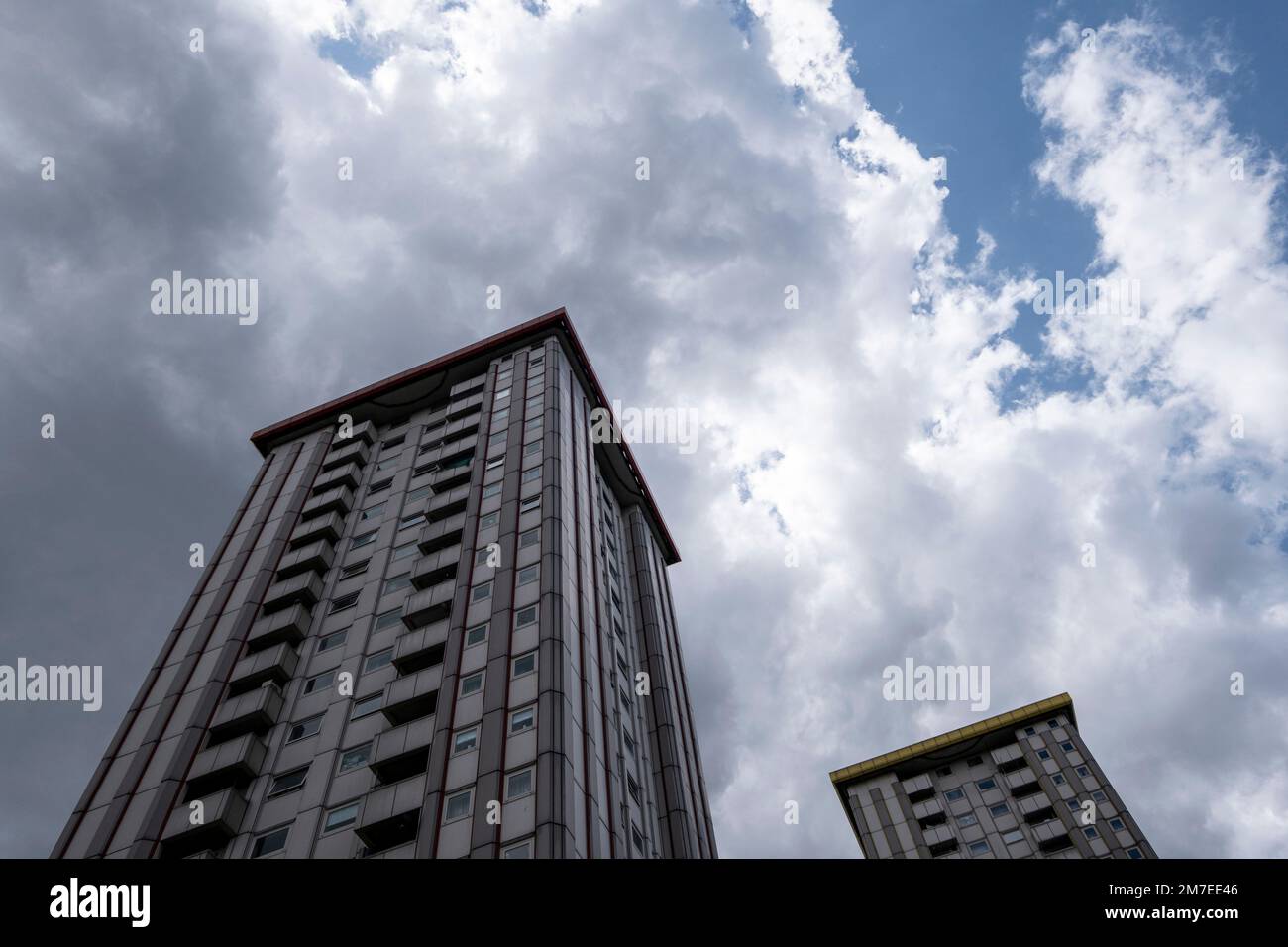 Looking up at high rise flats set aginst a blue sky with clouds Stock ...