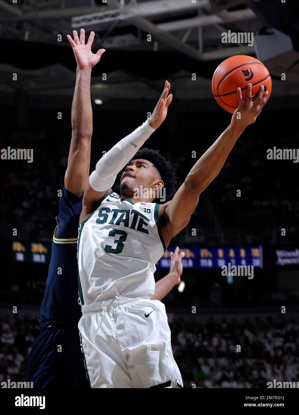 Michigan State's Jaden Akins, right, shoots against Michigan's Jett ...