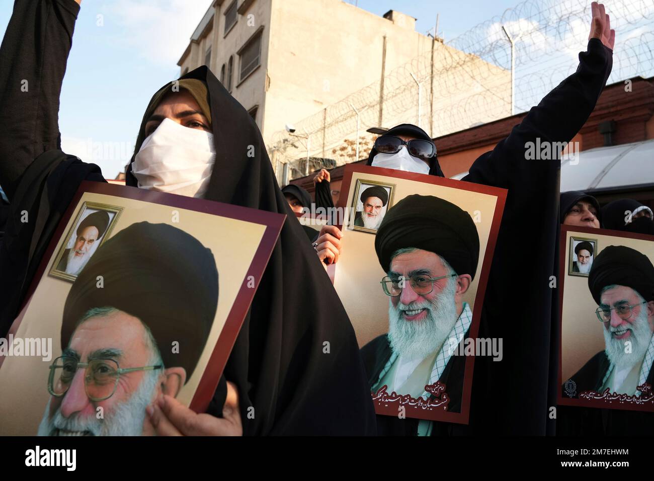 Iranian demonstrators chant slogans as they hold posters showing ...