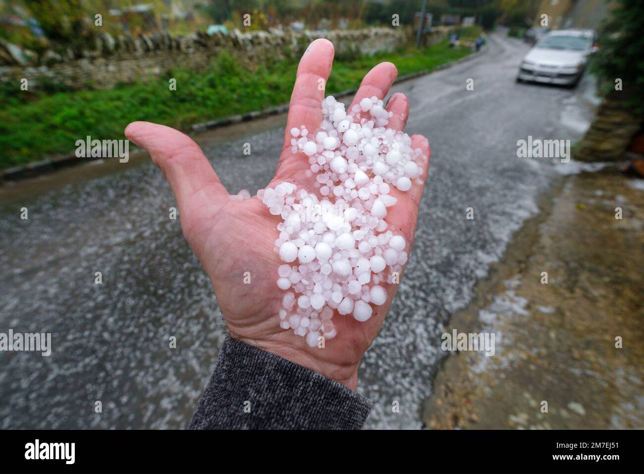 A mans hand holding Large hail stones after a violent storm in ...