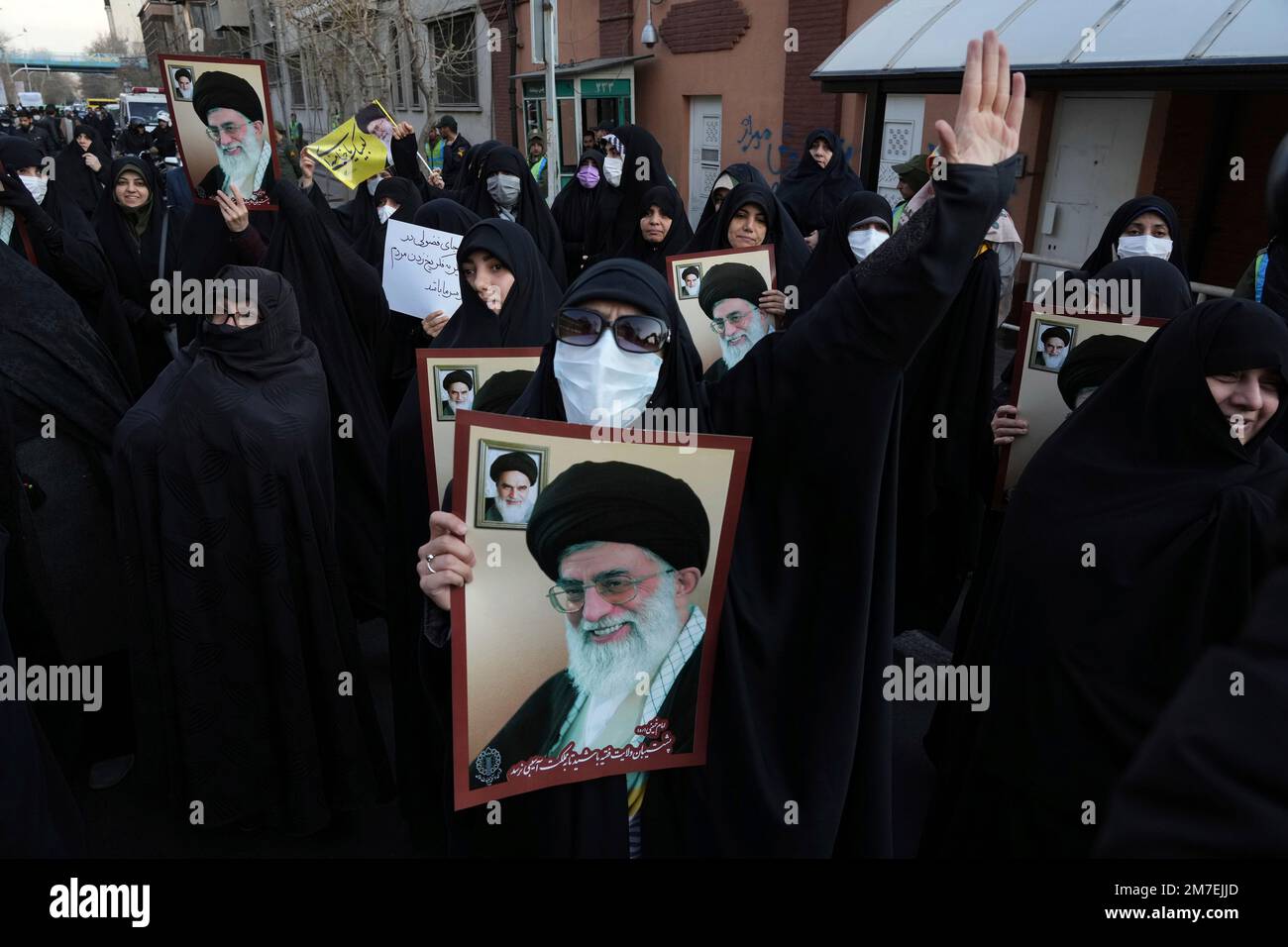 Iranian demonstrators chant slogans as they hold posters showing ...