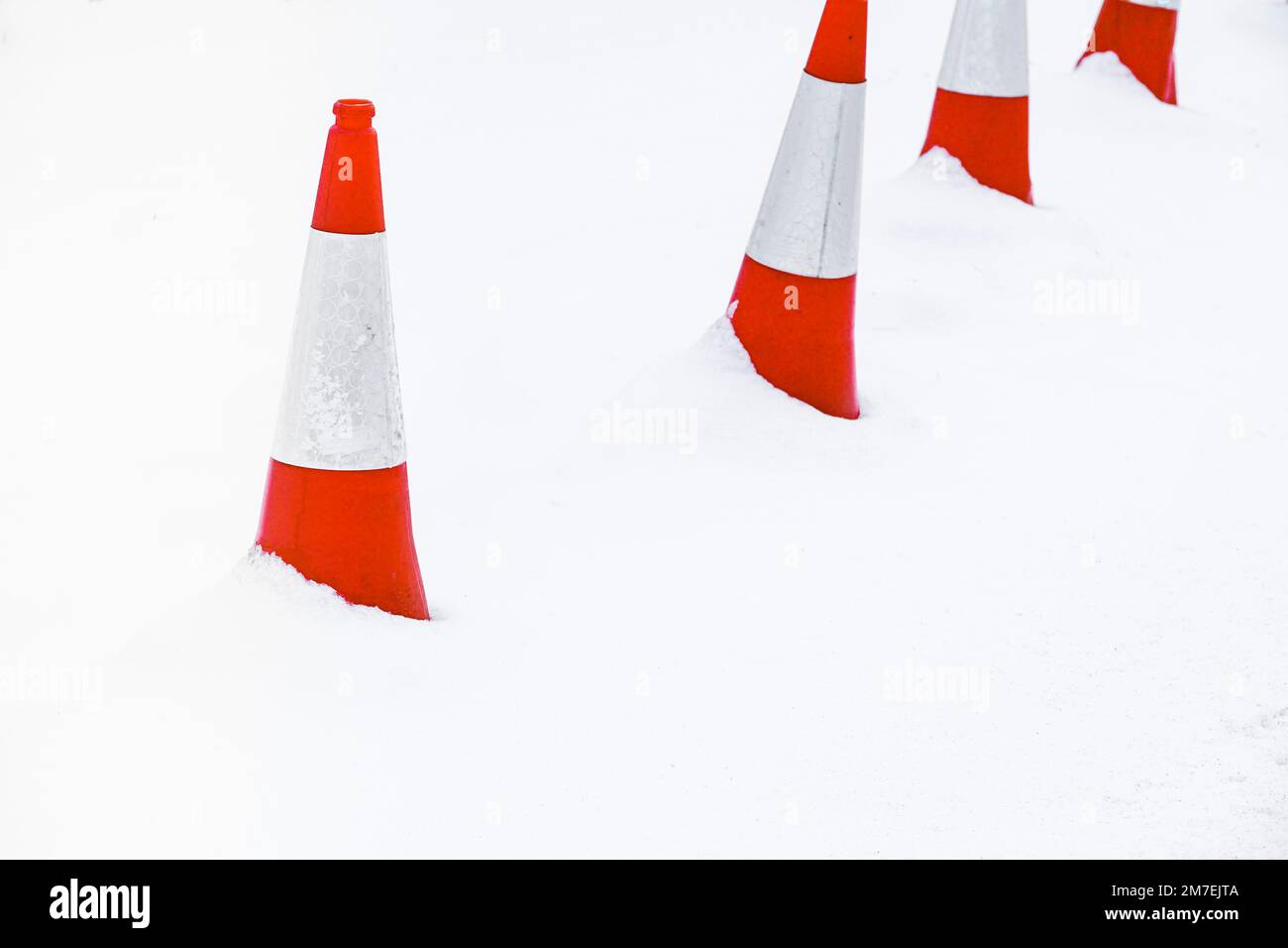 Traffic cones almsot hidden in snow on the edge of a country road Stock ...