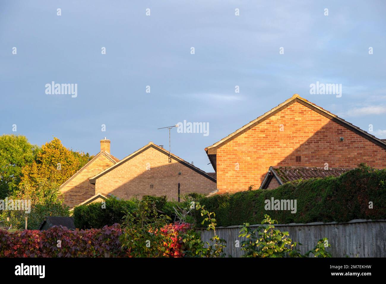 The side of brick built houses in the sunshine on a housing estate in ...