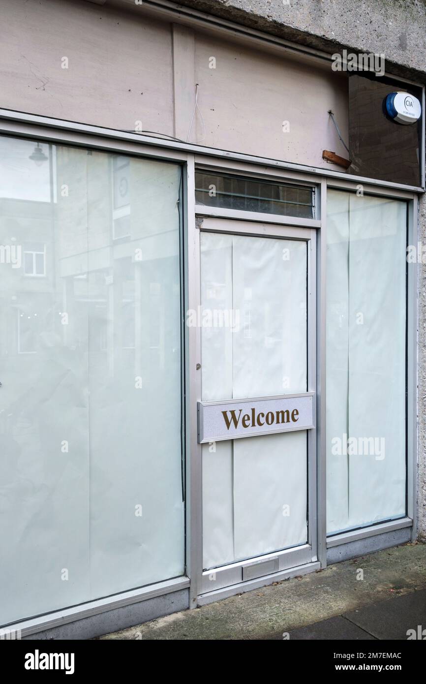 An old shop front closed and papered over but still iwth a welcome sign ...
