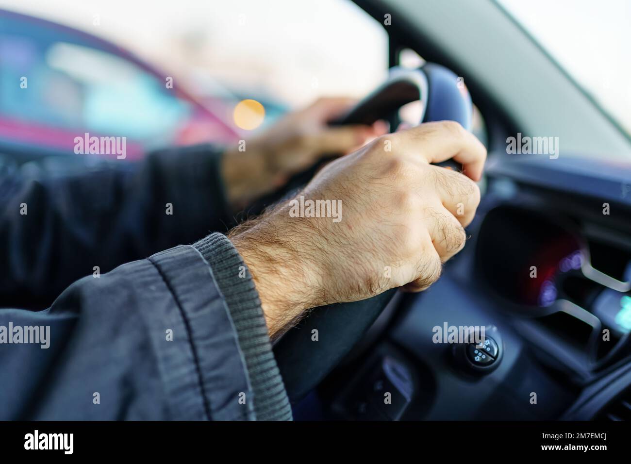 Man's hands taking the wheel of the car and driving at sunset Stock ...