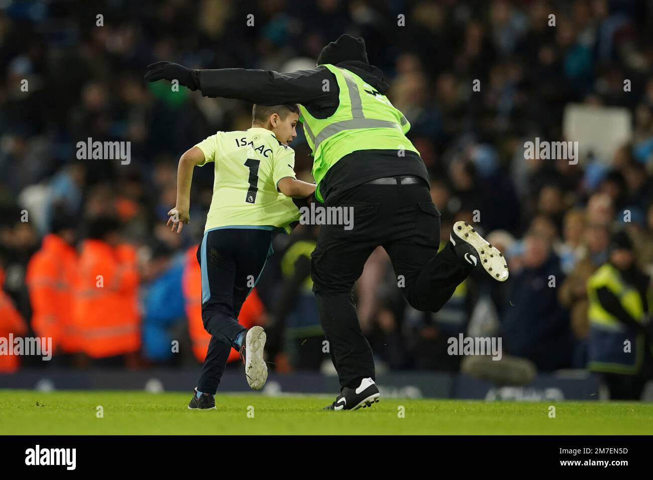 A security official chases a boy who invaded the pitch during the ...