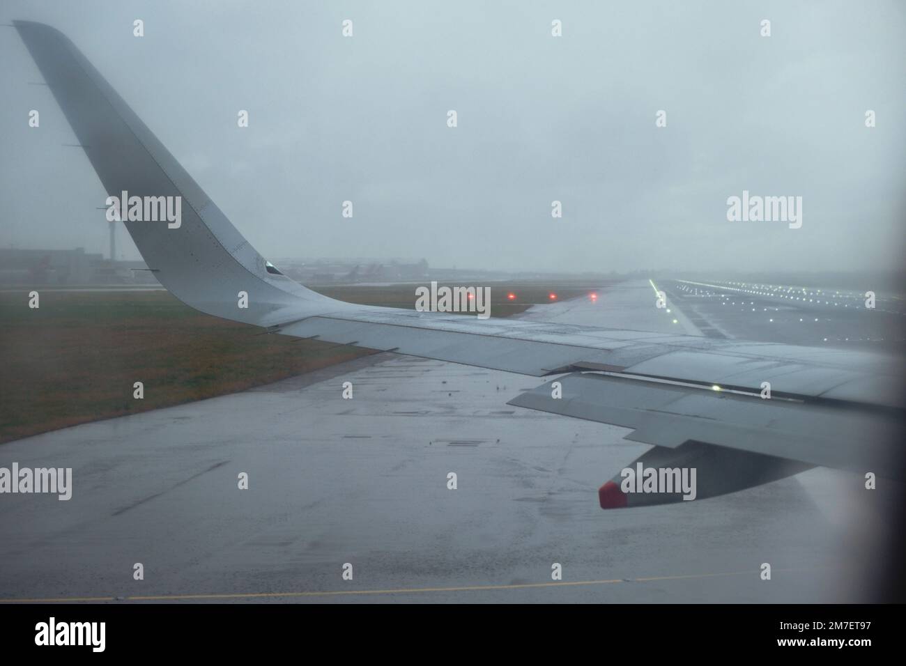 View through an aeroplanes window at with rain streaming across the ...