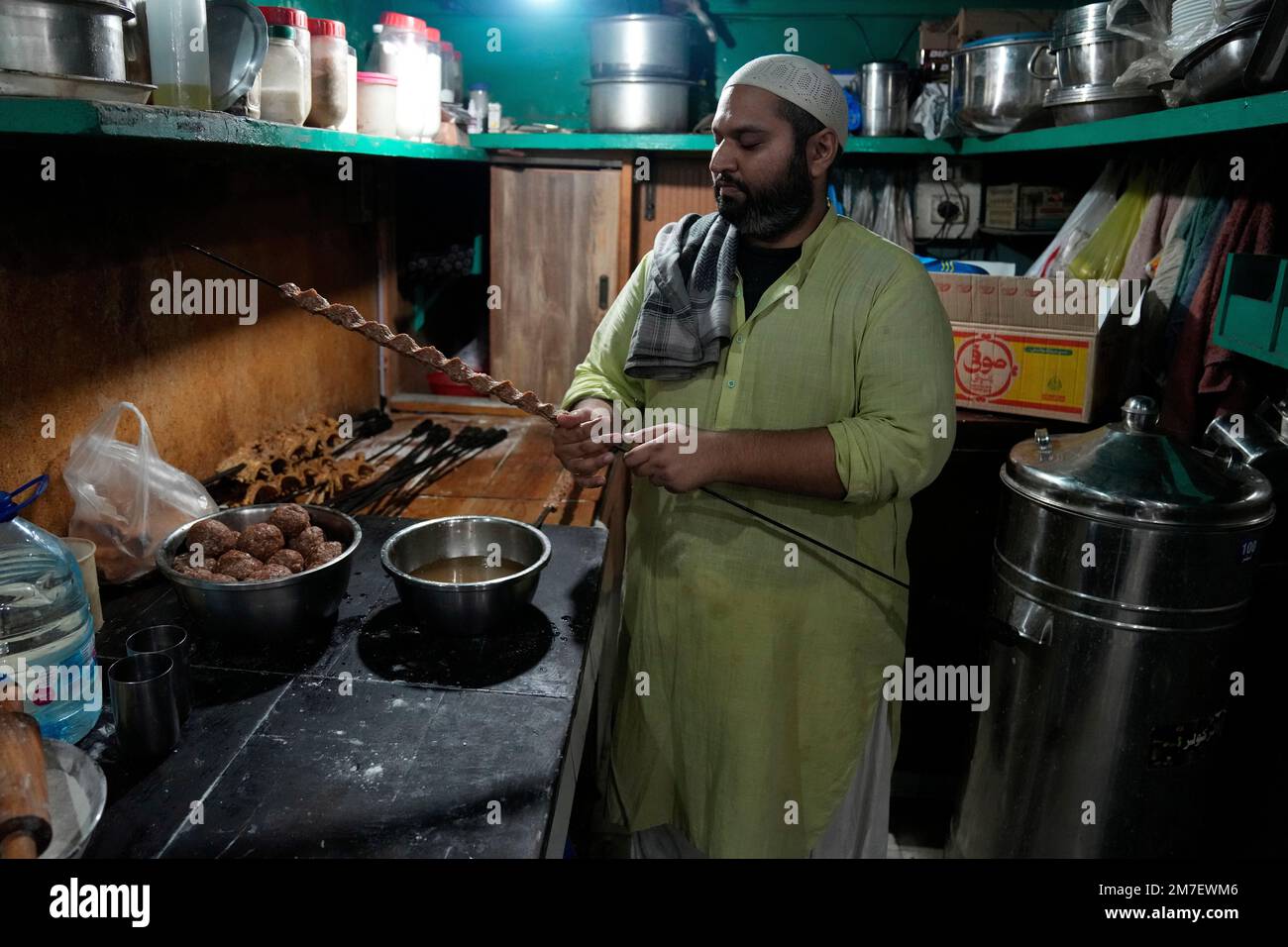 Bilal Sufi, owner of Baking Virsa eatery, prepares kebabs in Lahore ...