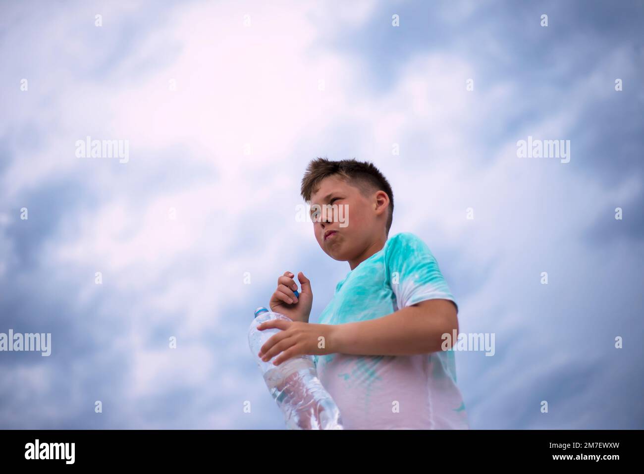 A boy with a bottle of clean water against the backdrop of a demonic ...