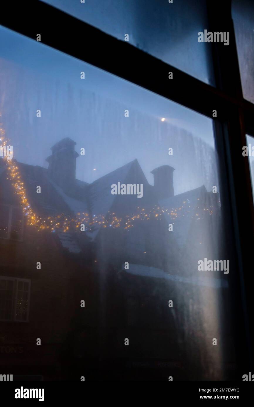 View through a coffee shop window to the night time street scene ...