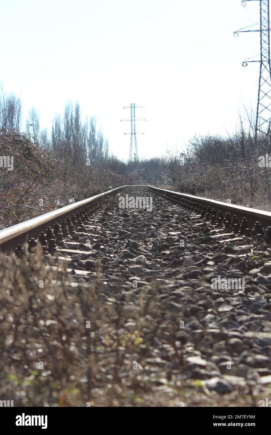 A vertical ground level shot of the rails of a train in a desolated ...
