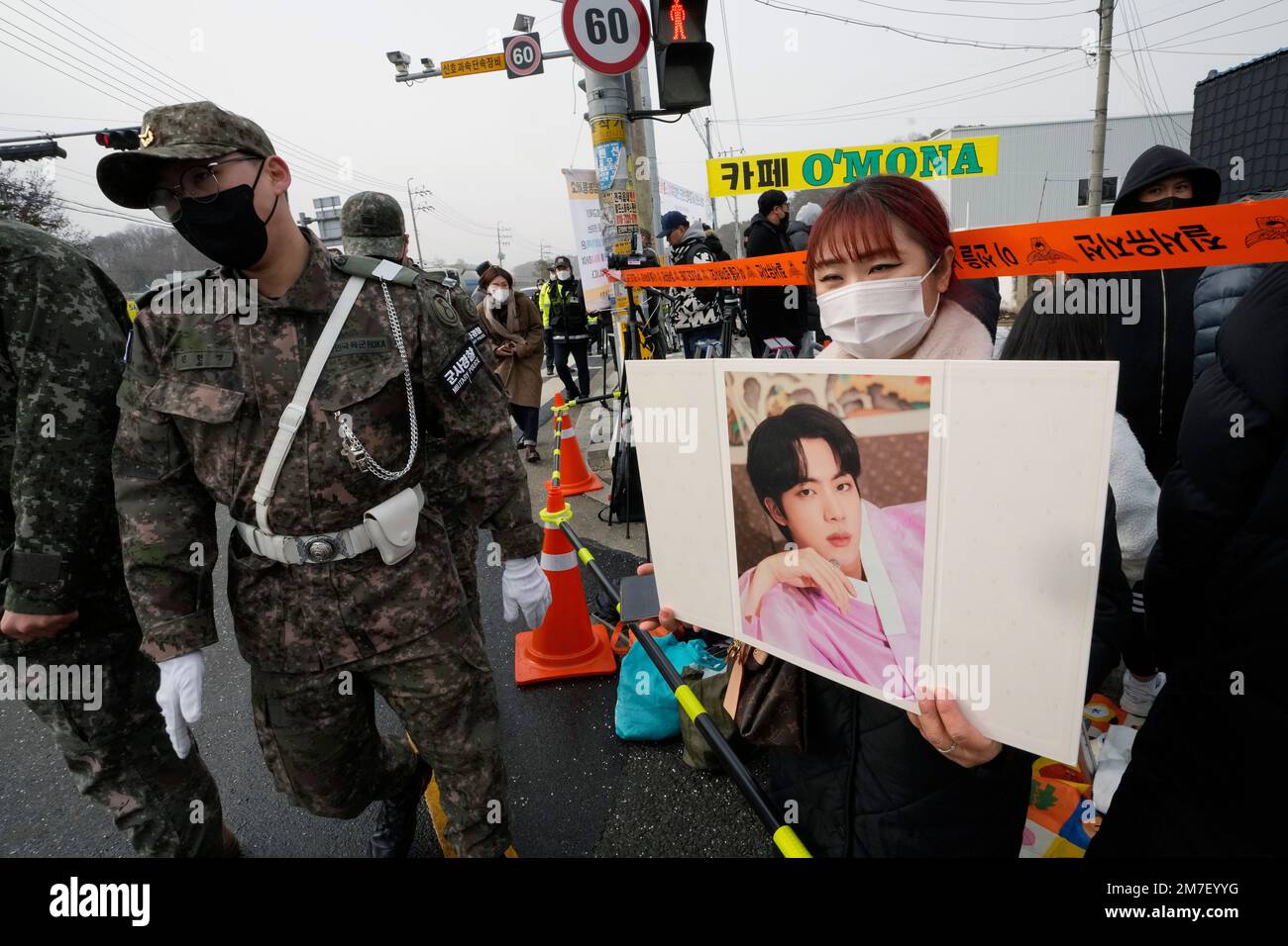 A fan waits for K-pop band BTS's member Jin to arrive before he enters ...