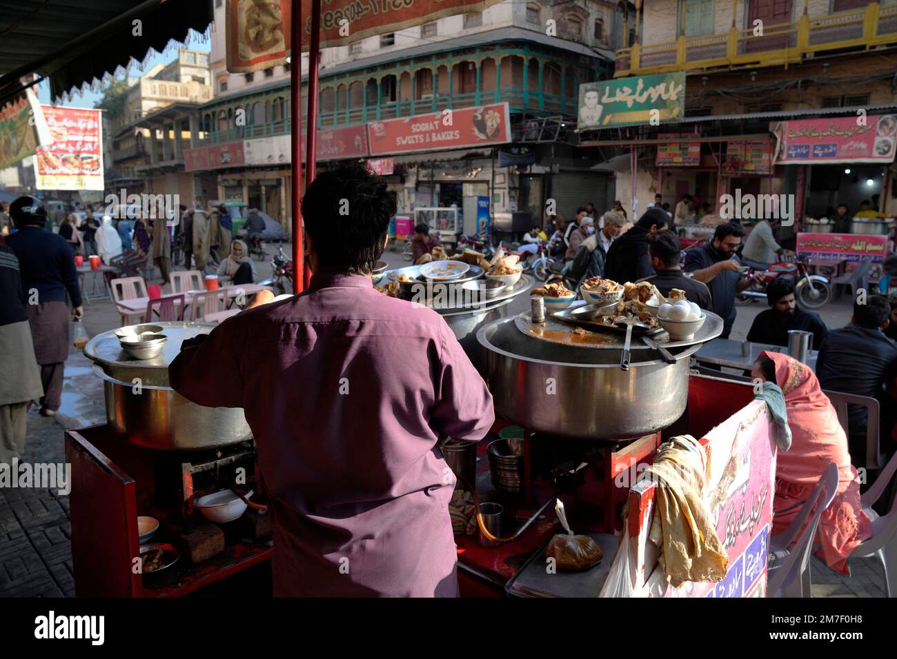 People eat breakfast at a famus food street of Gawalmandi, an old area ...
