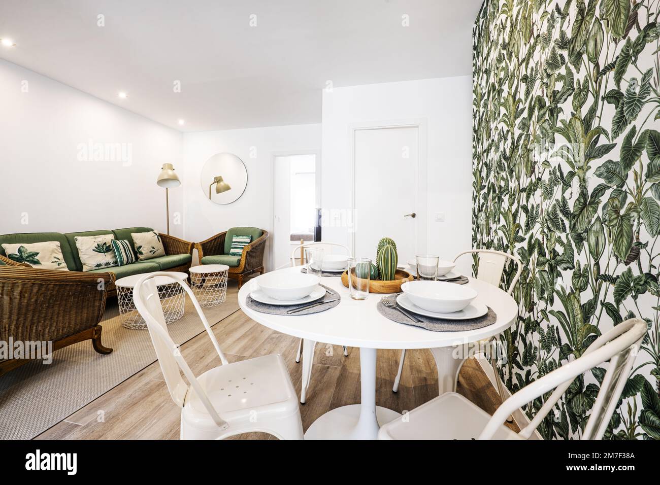 Living room with round white wood dining table with food service and ...