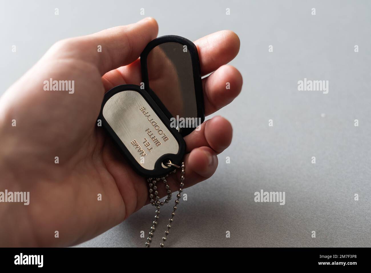 Man holding military ID tag on white background, closeup Stock Photo ...