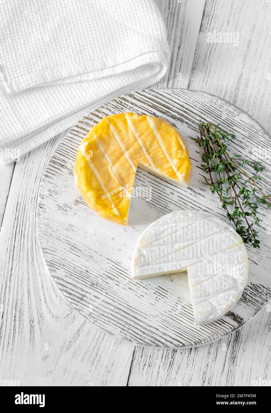 Two camembert cheese wheels on the cutting board Stock Photo - Alamy