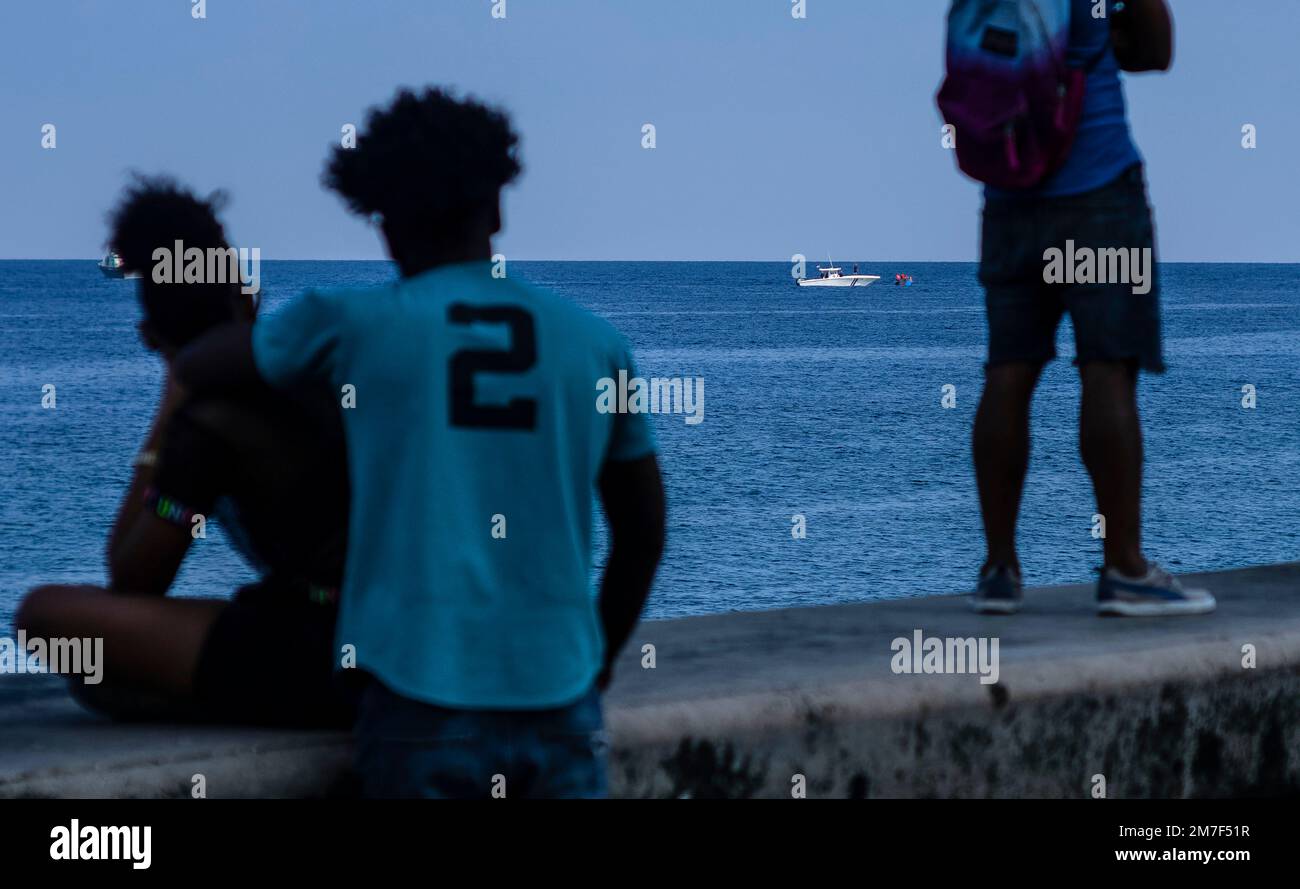 People watch the Cuban Coast Guard capture a makeshift boat, from the ...