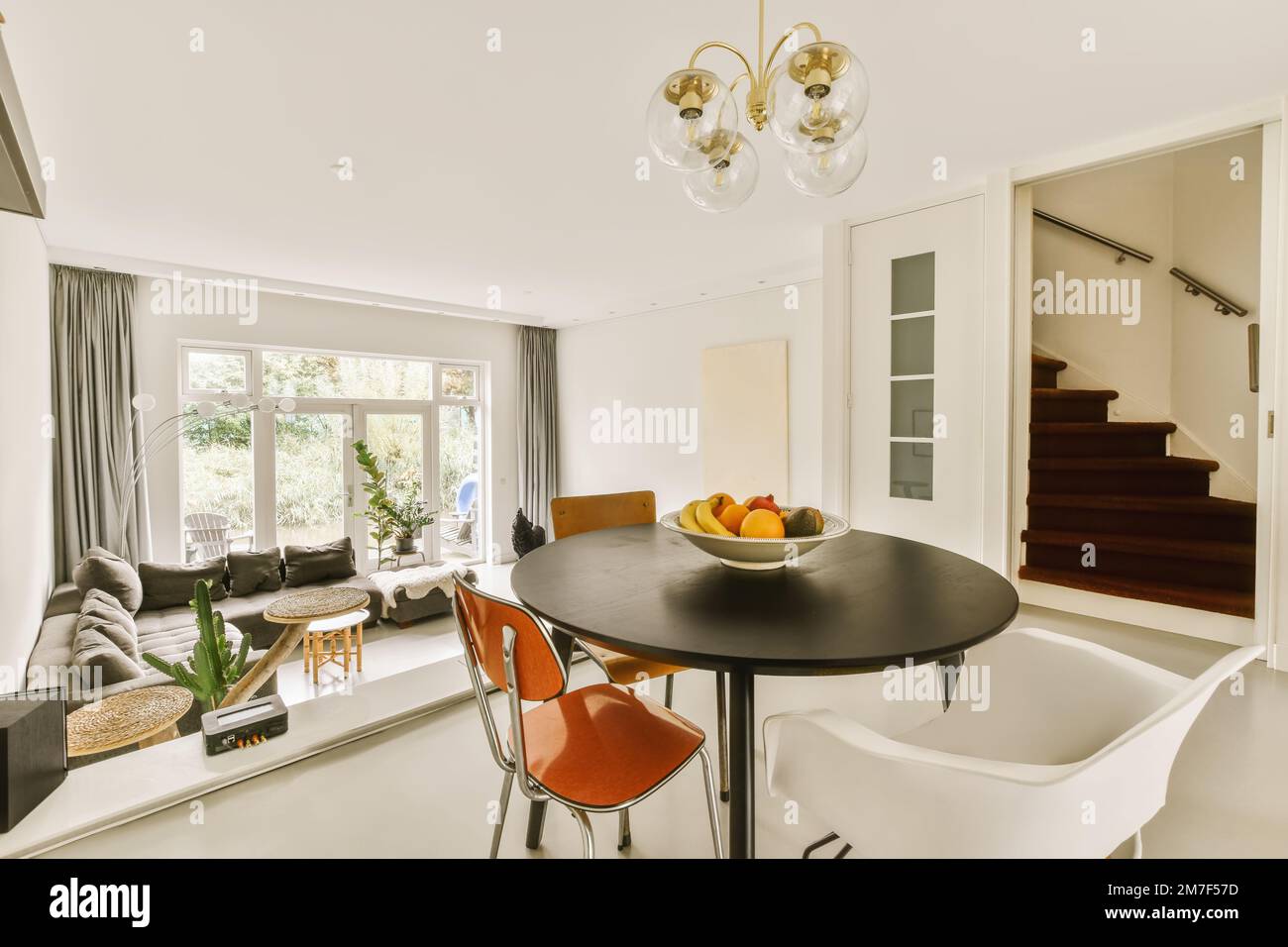 a living room with a dining table and two chairs in front of an open ...