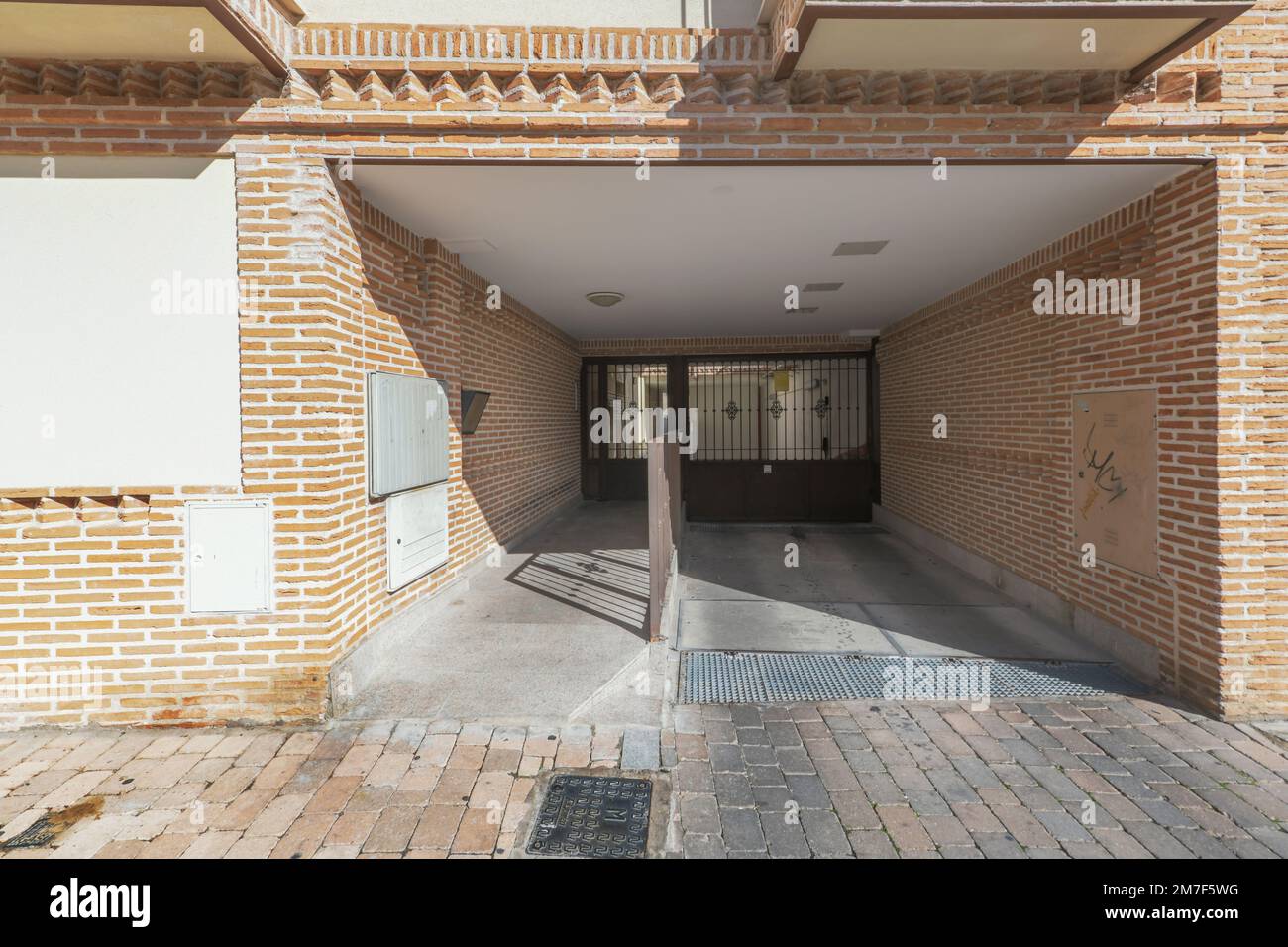 Facade of a building with clay bricks, a black metal portal and an ...