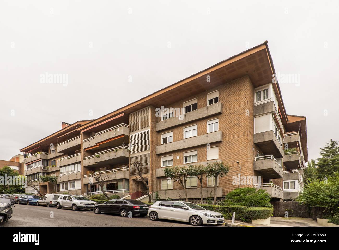 Image of facades of a building with a roof with large eaves and gardens ...