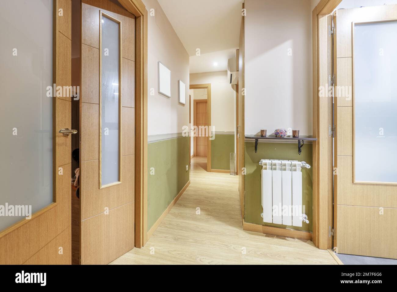 Entrance hall of a house with access to several rooms through oak doors ...