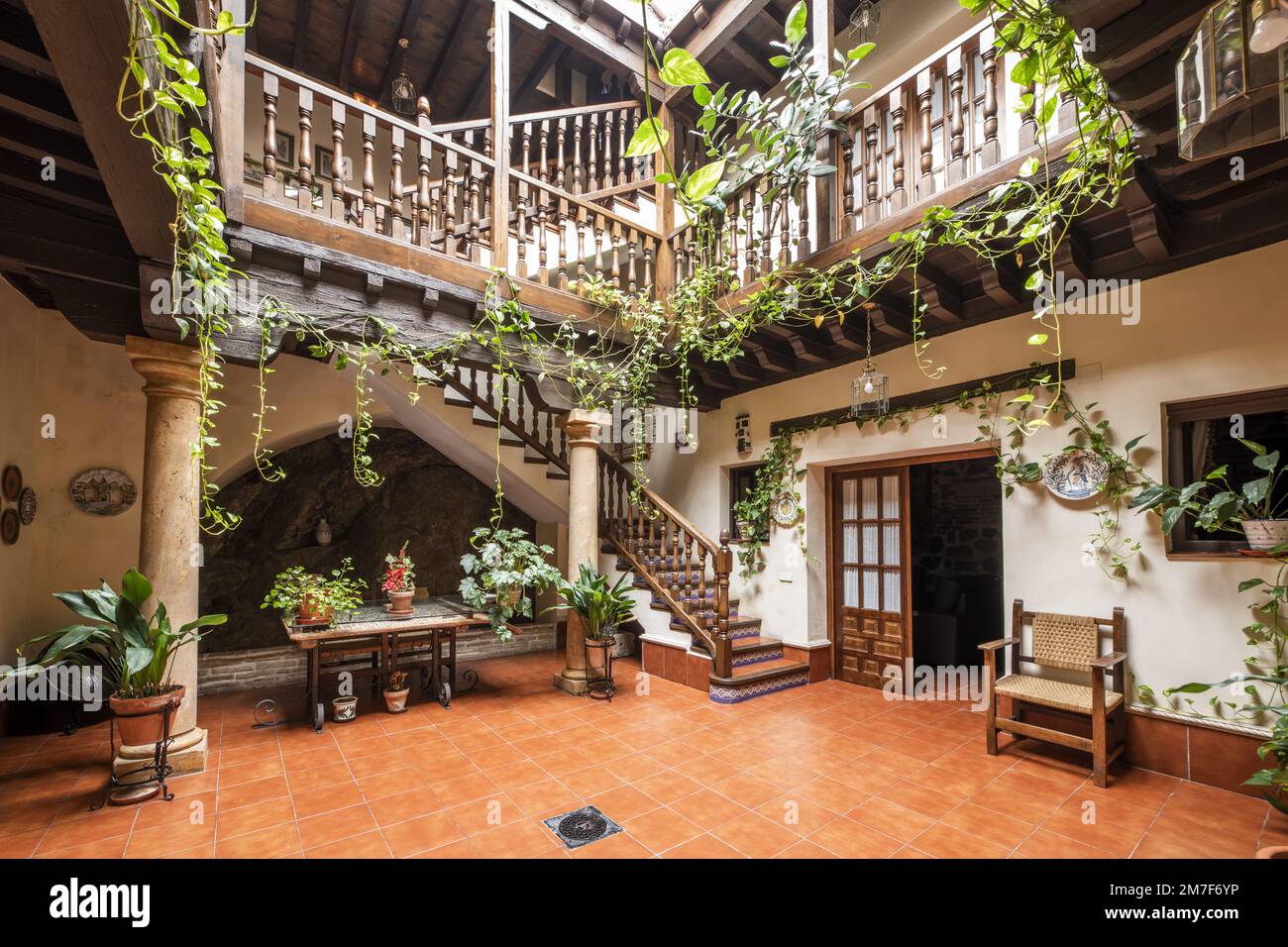 Atrium of an old house with wooden railings on stairs and on the floors ...