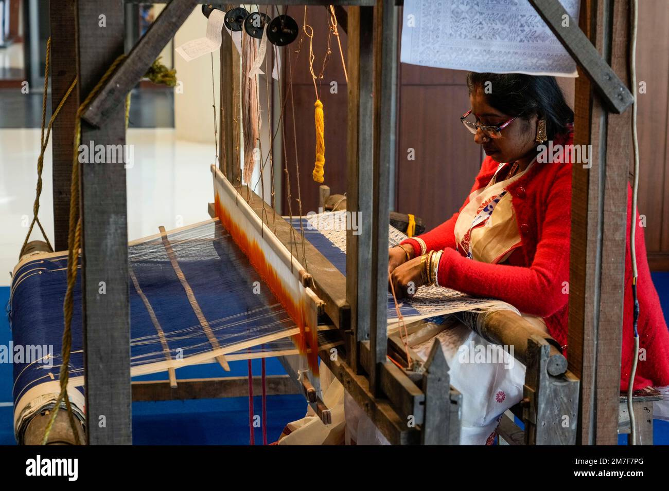 A woman weaves a sari on a traditional hand-loom machine during 'Global ...