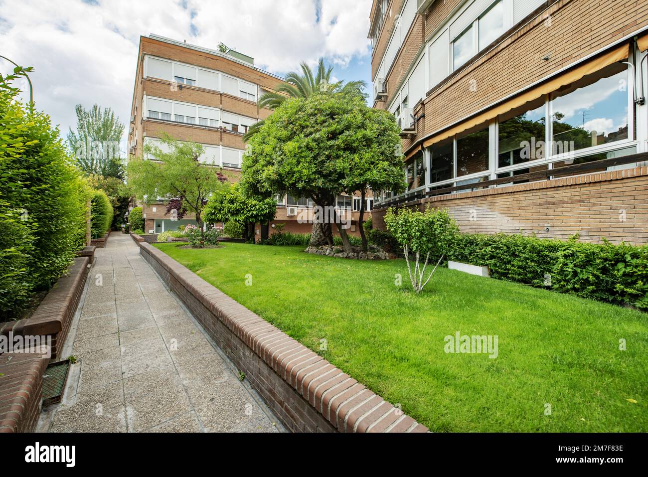 Facade of a four-story building with white aluminum windows and ...