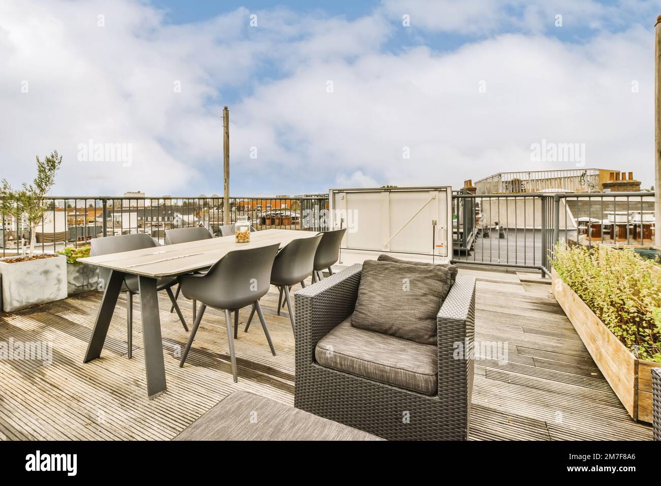 a roof deck with chairs, tables and an outdoor dining area in the fore ...