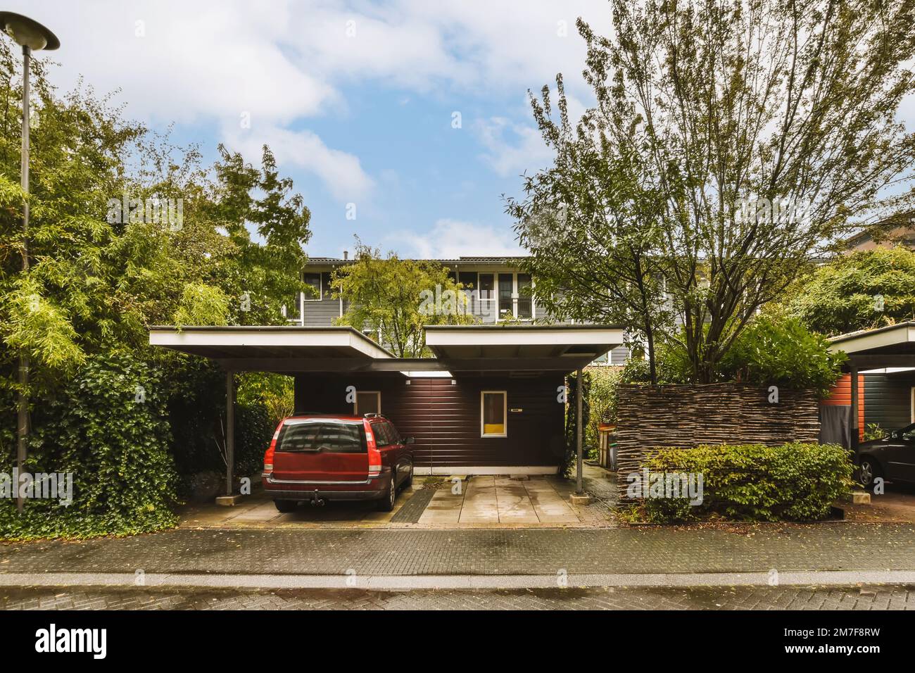 a house with a car parked in the driveway and two cars parked next to ...