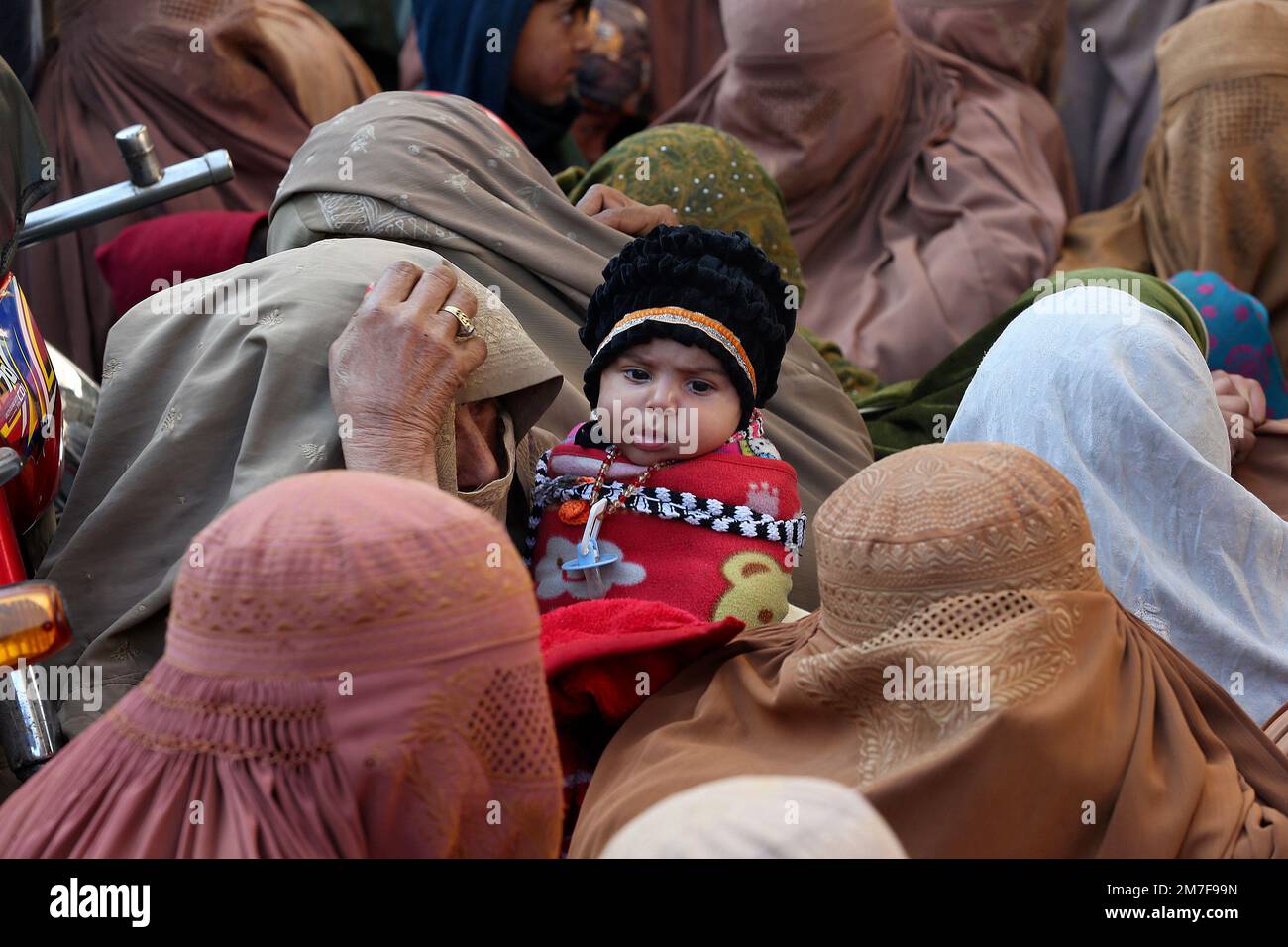 People stand in a long queue and wait to buy subsidized sacks of wheat ...