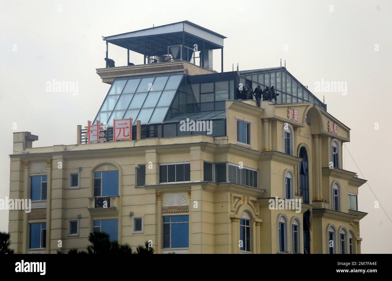 Taliban fighters are seen in the rooftop of a hotel building during a ...