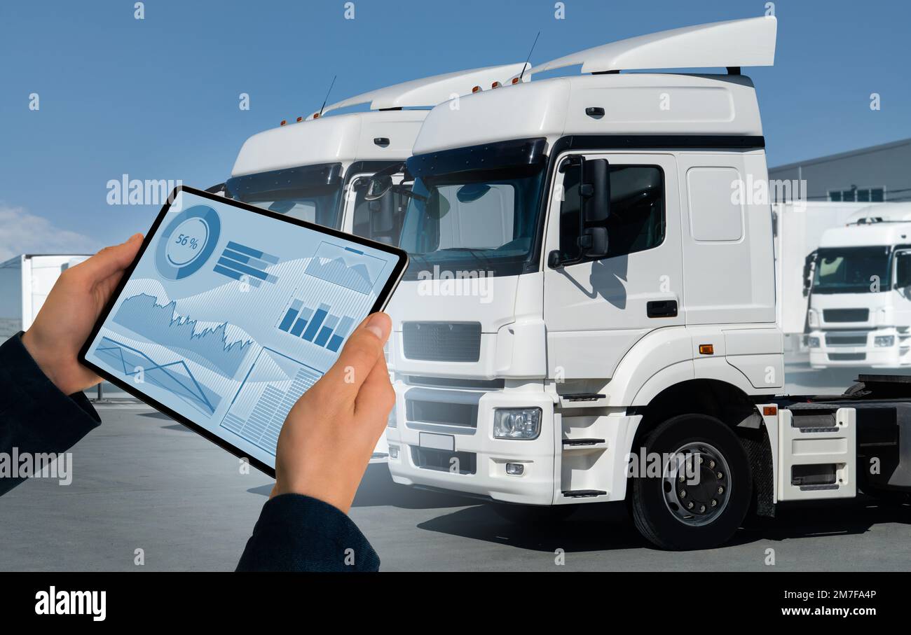 Manager with a digital tablet next to trucks. Fleet management Stock ...