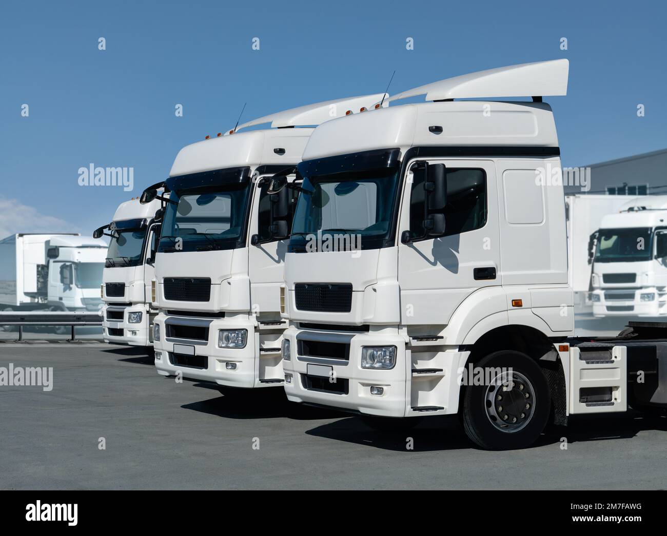 Fleet of white semi trucks in a row Stock Photo - Alamy