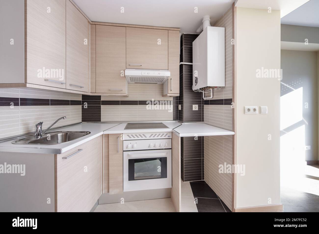 Small kitchen of a loft apartment with light wood cabinets with white ...