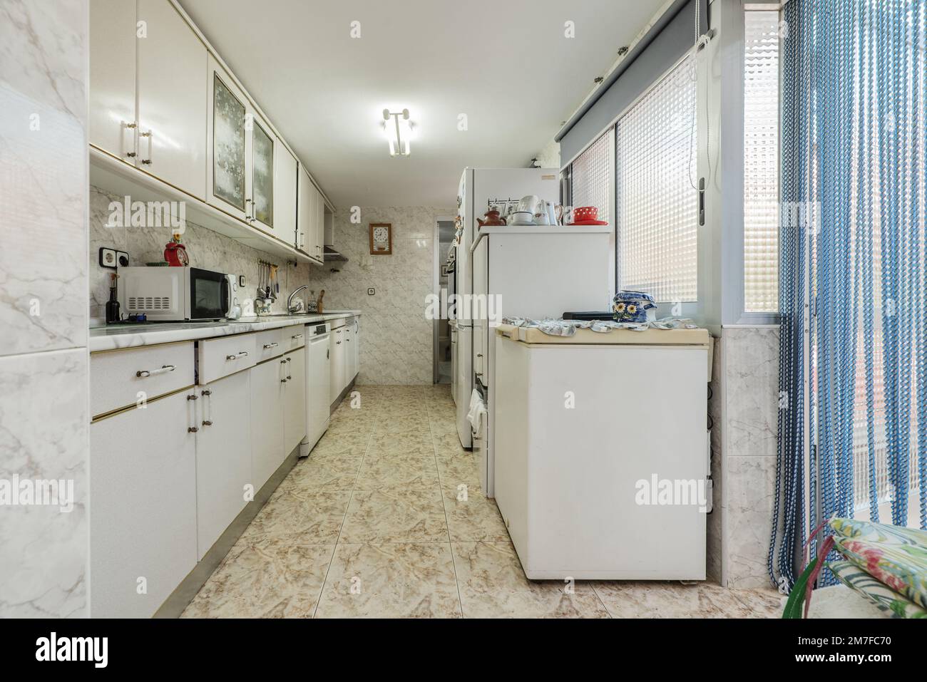 kitchen of a low house with access to a terrace with old furniture and ...