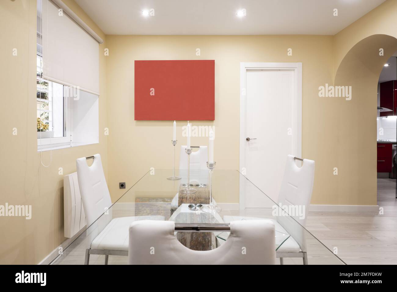 Living room with glass table, chairs upholstered in white skay and ...