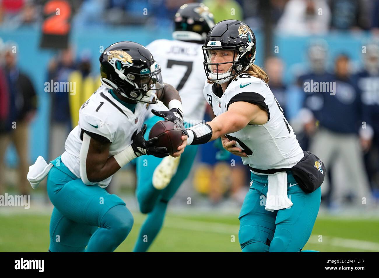 Jacksonville Jaguars quarterback Trevor Lawrence, right, hands off to ...