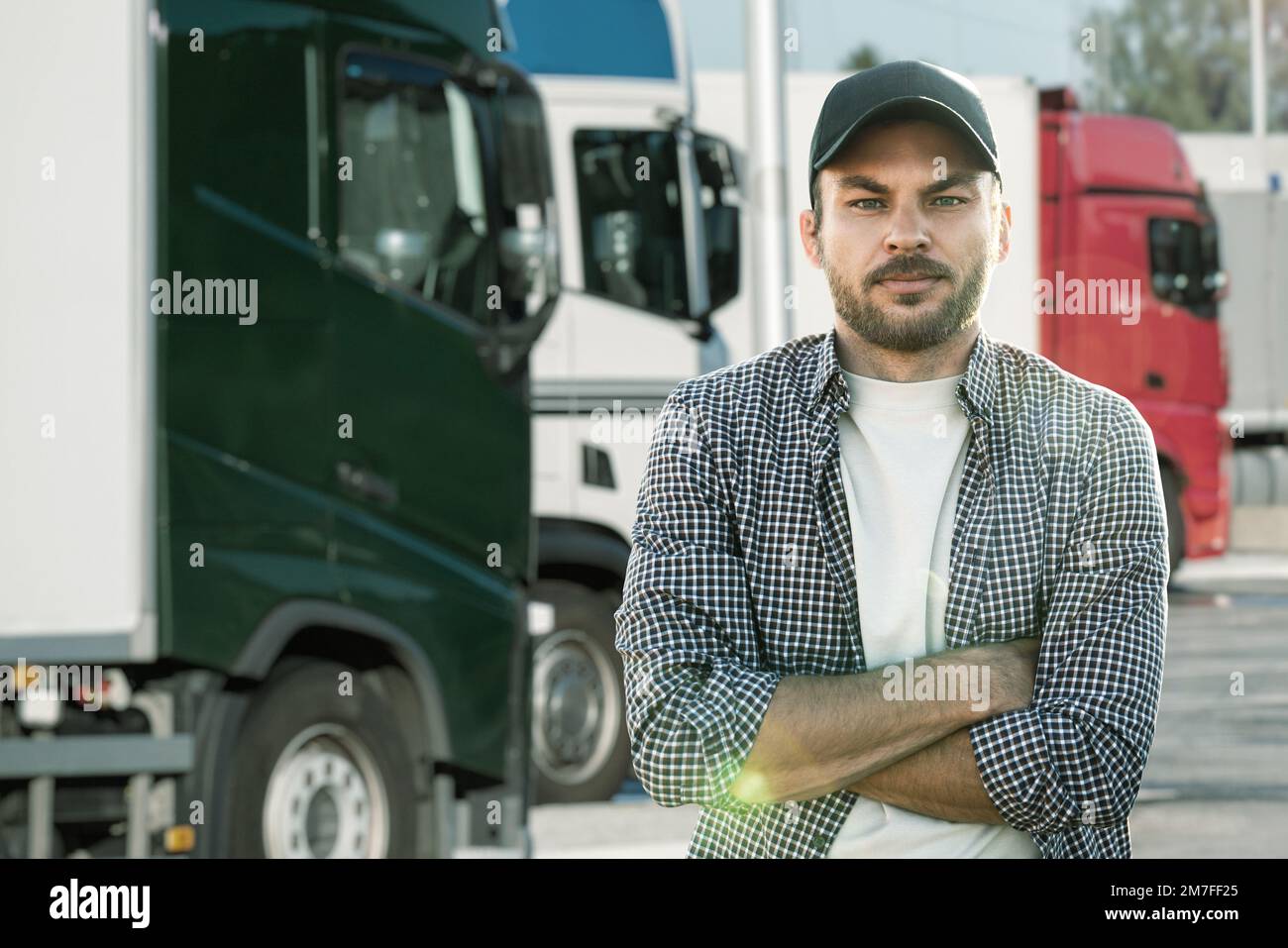 Truck driver standing in front of trucks Stock Photo - Alamy