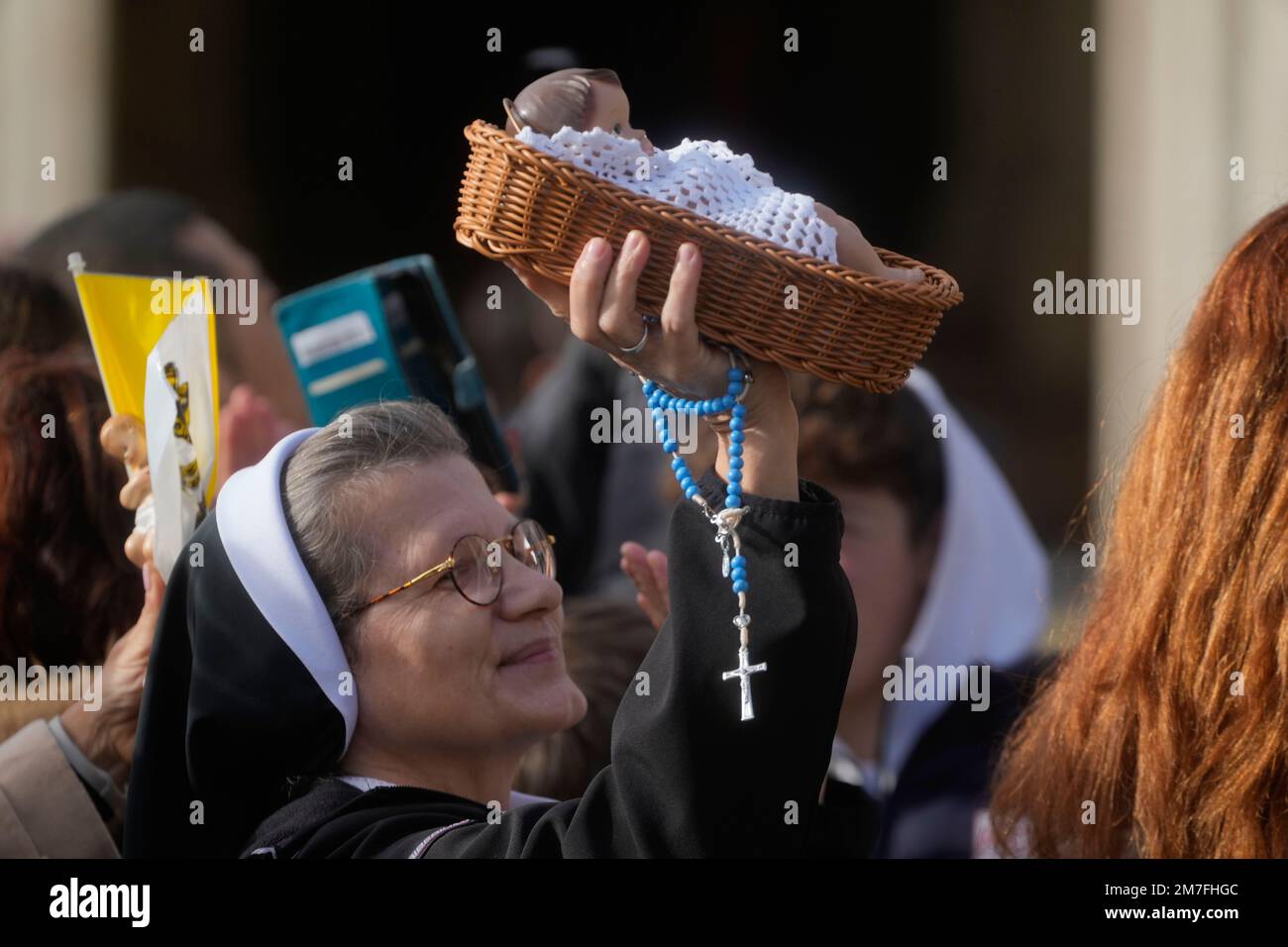 A nun holds up a statue of baby Jesus during Pope Francis' Angelus noon ...