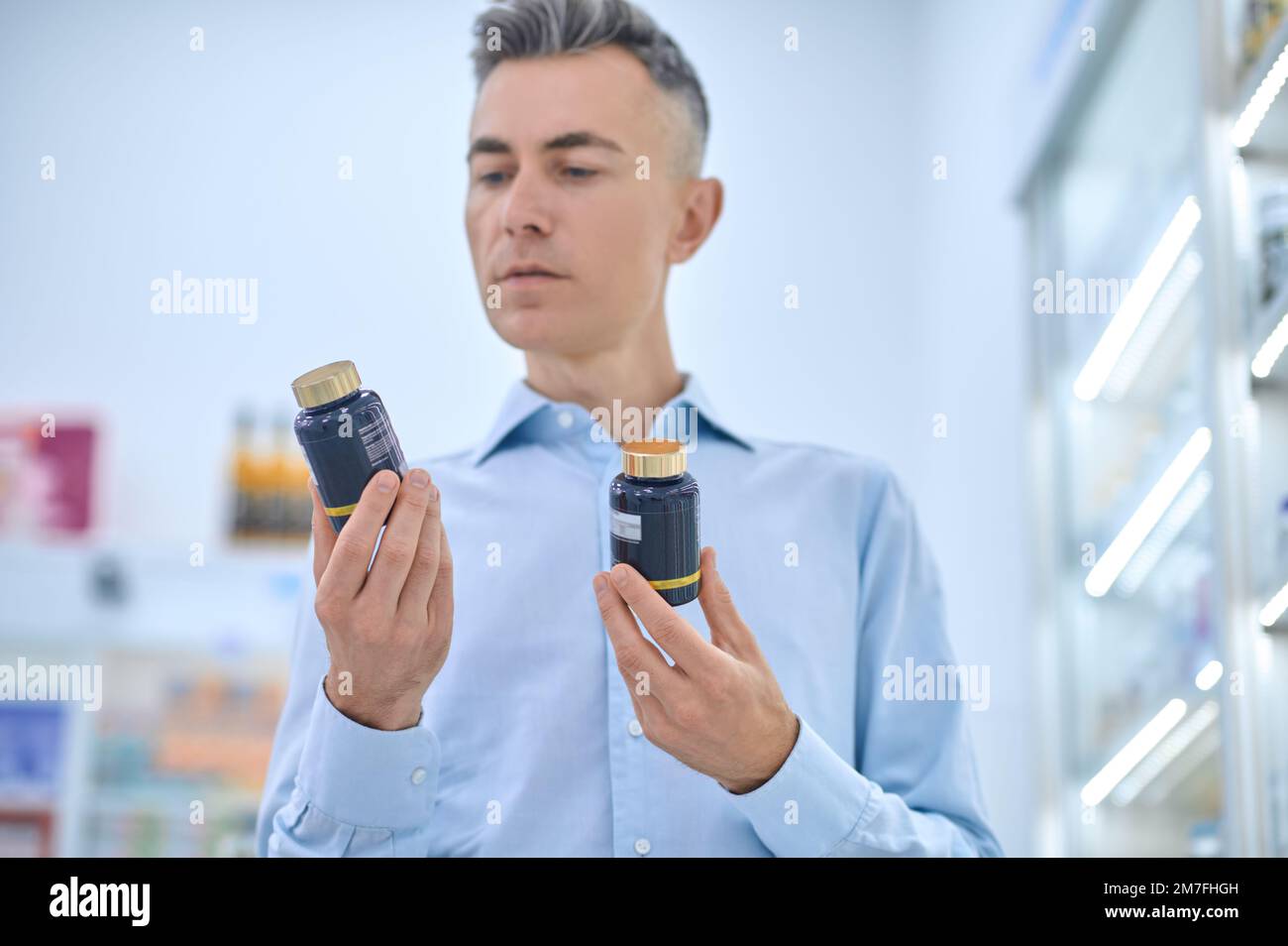 Mid aged man choosing supplements at the drugstore Stock Photo - Alamy