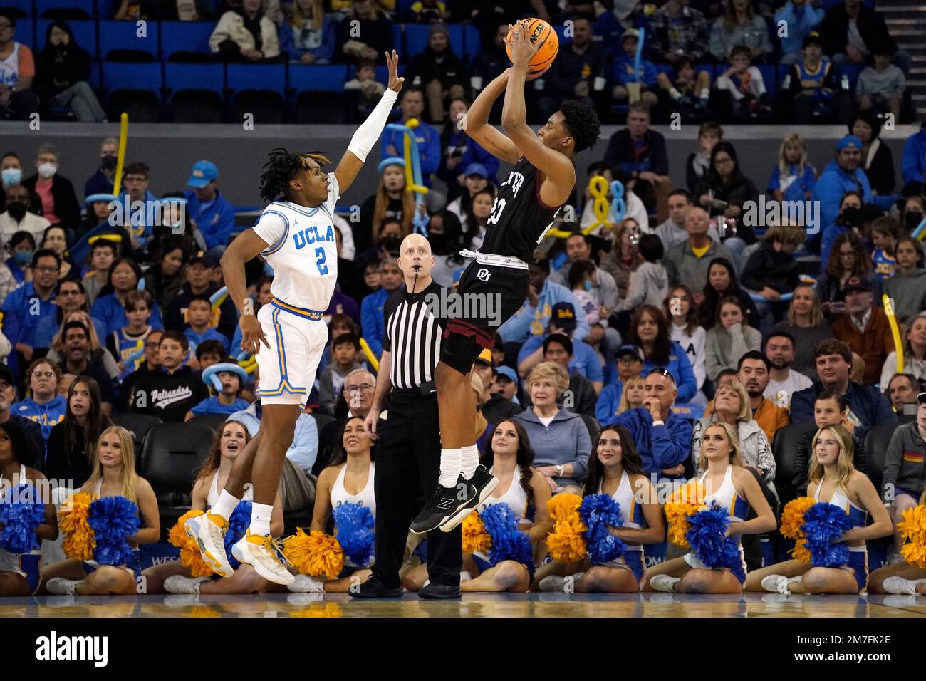 Denver guard Justin Mullins, right, shoots as UCLA guard Dylan Andrews ...
