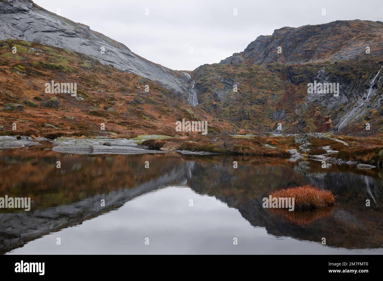 In cloudy weather, the landscape is reflected in a mountain lake near ...