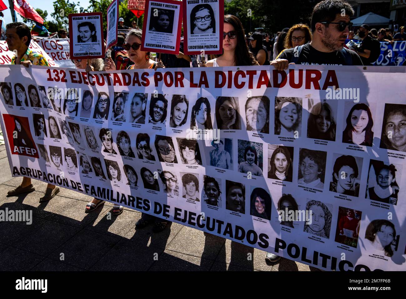 Protesters hold a banner with pictures of people killed during the ...