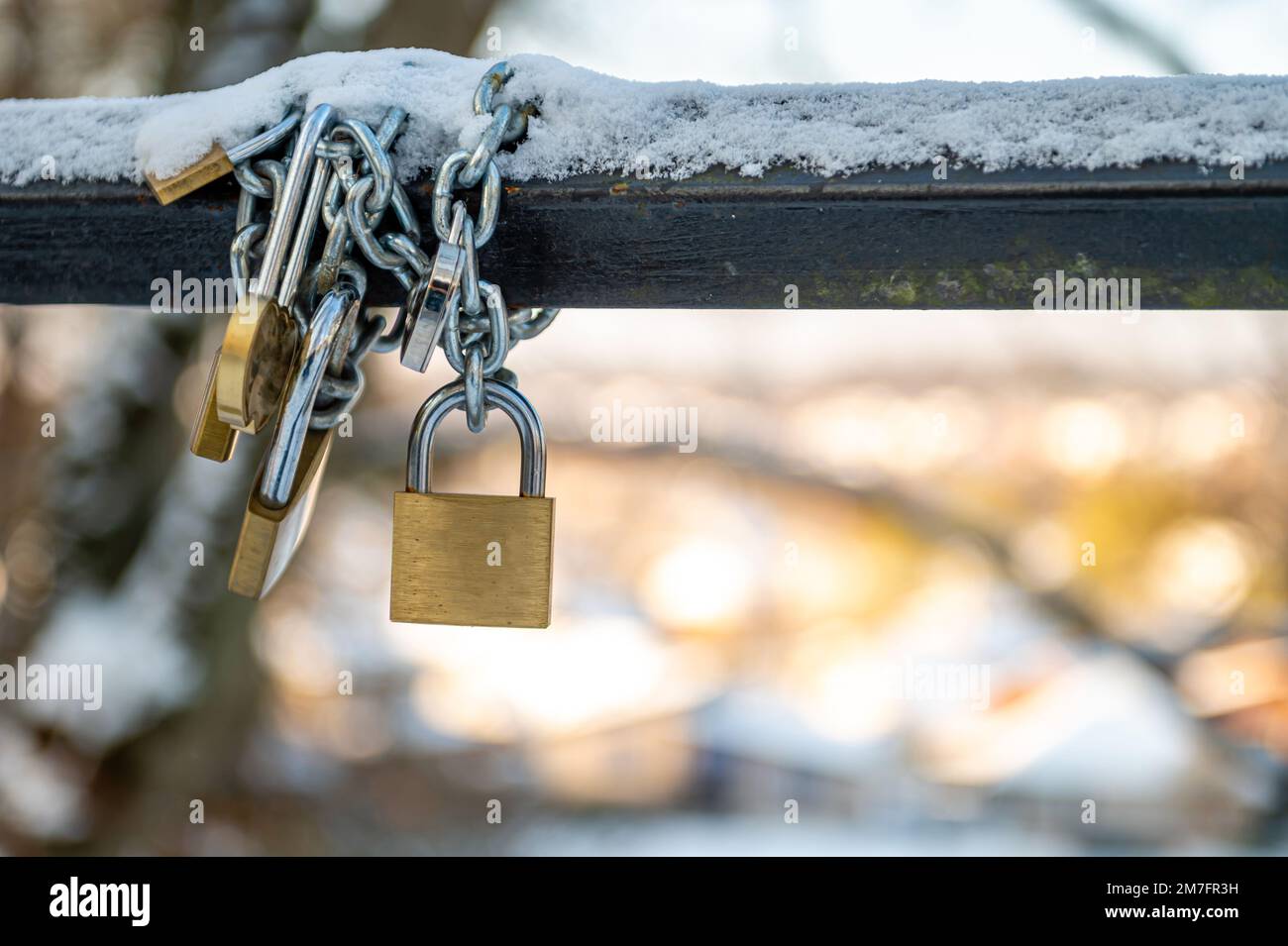 Traditional locks of lovers on the bridge across the river in winter ...